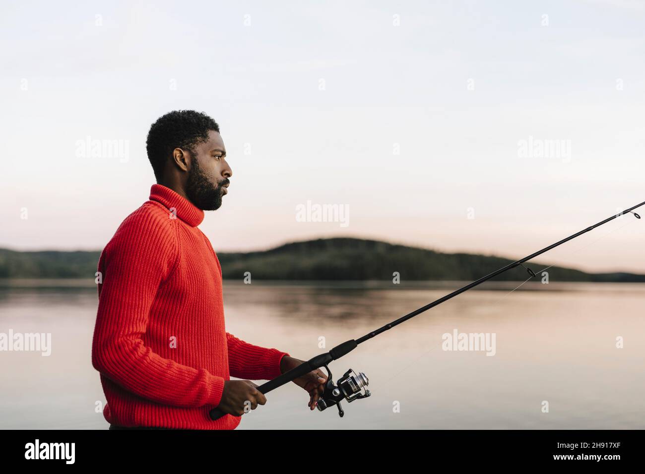 Side view of man fishing during sunset Stock Photo - Alamy