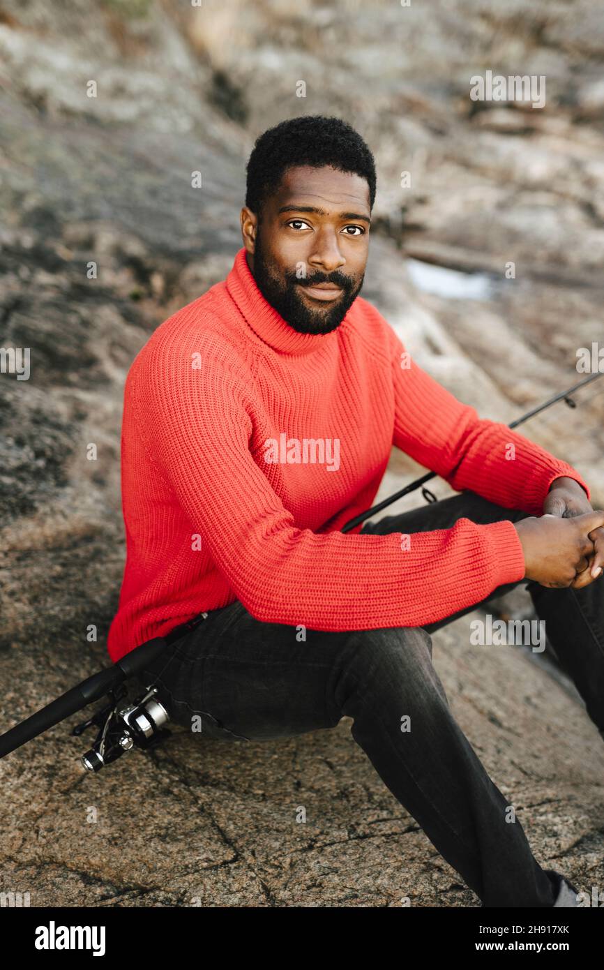 Man sitting on rock fishing hi-res stock photography and images - Alamy