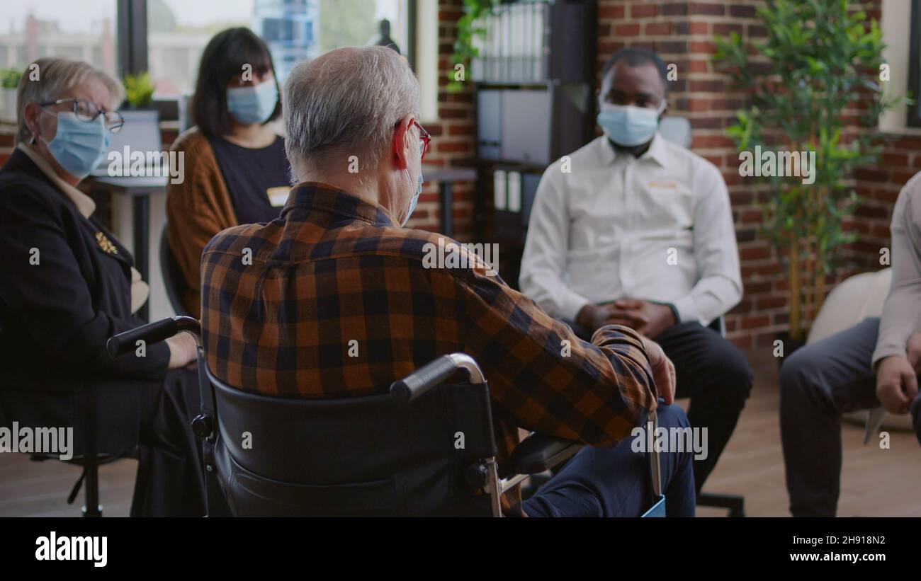 Senior man with disability attending aa group therapy session with ...