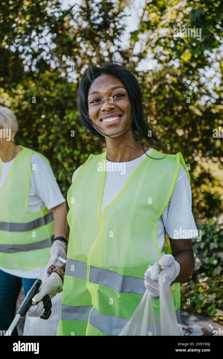Portrait of smiling female environmentalist holding plastic bag Stock ...