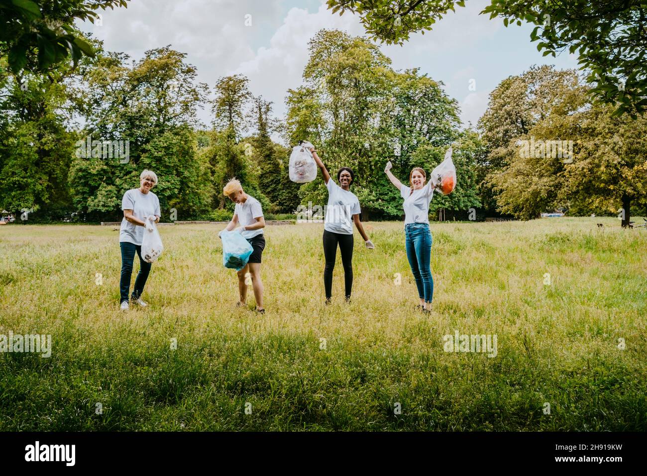 Cheerful female and male environmentalists cleaning park Stock Photo ...