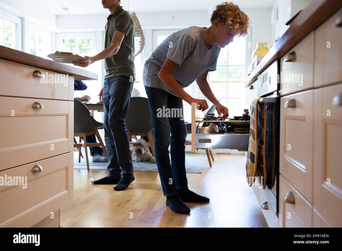 Brothers searching in drawer while doing chores at kitchen Stock Photo ...