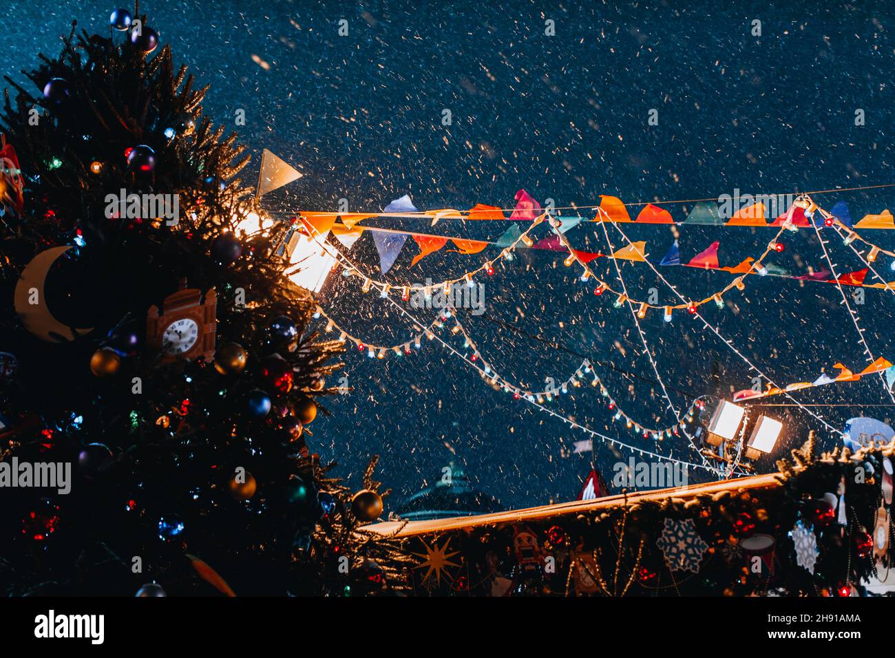 Christmas tree and flying snow in the evening light in festive magic ...