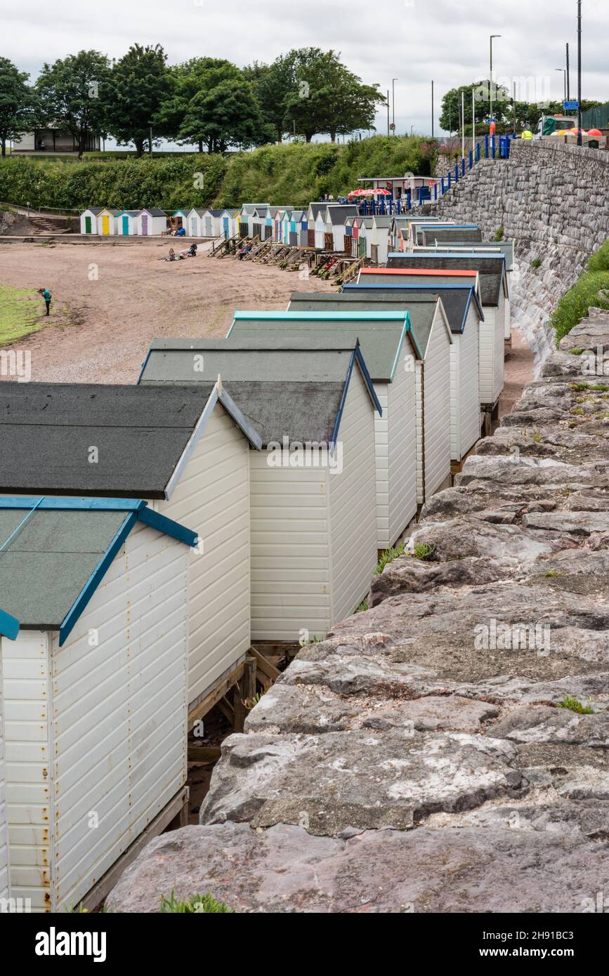 Row of beach huts along stone wall on beach, Torquay, Devon, UK Stock ...