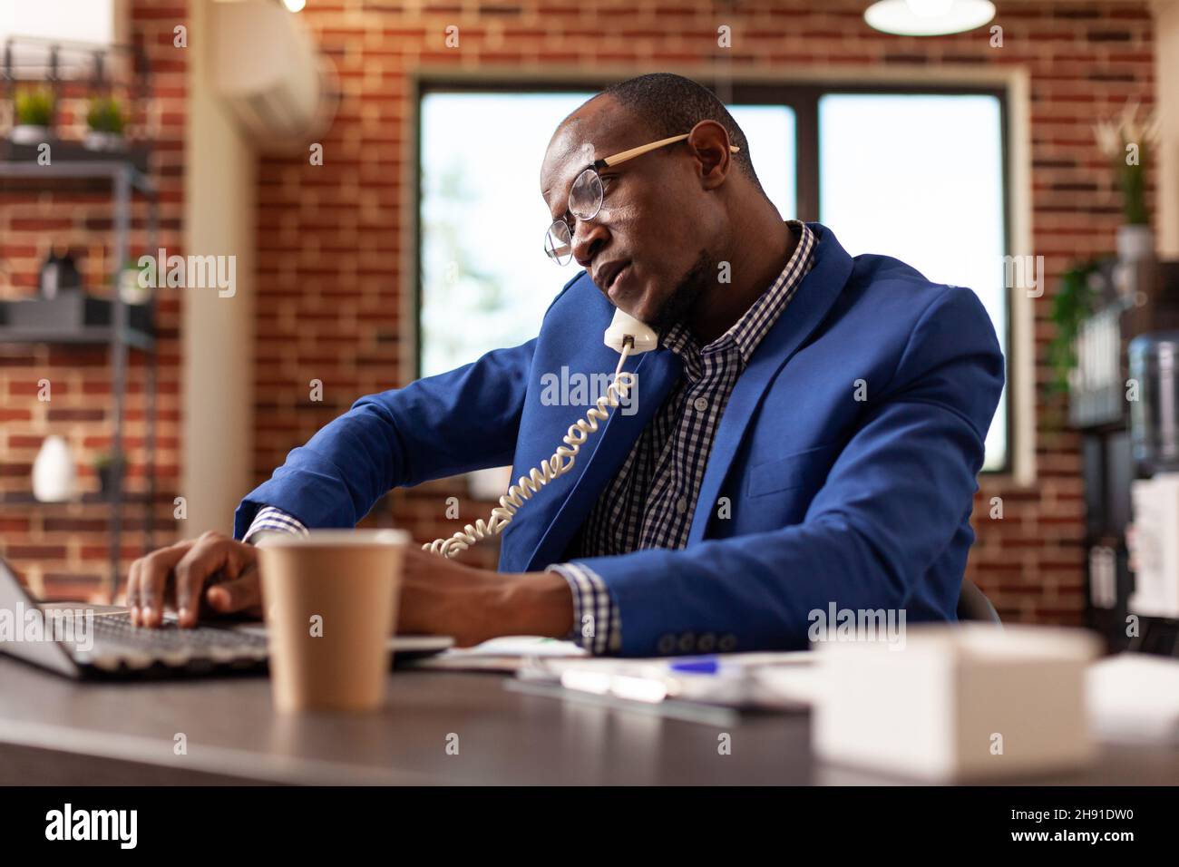 Business man answering call on landline phone in office to talk about ...