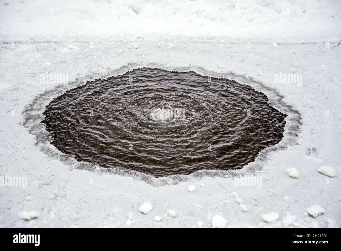 A round hole in the ice of a winter pond in a snow-covered park Stock ...