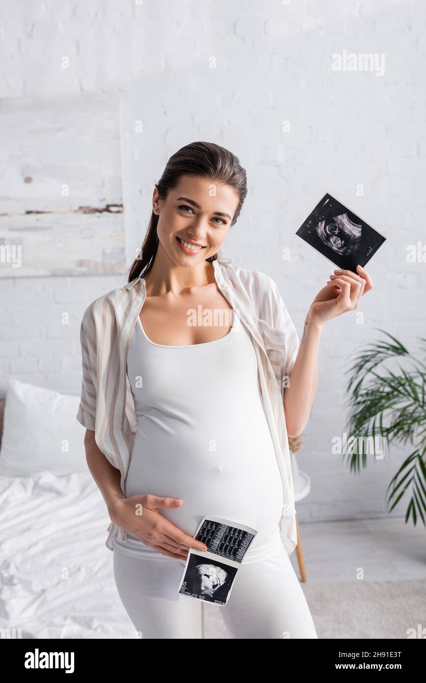 positive and pregnant woman holding ultrasound scans Stock Photo - Alamy
