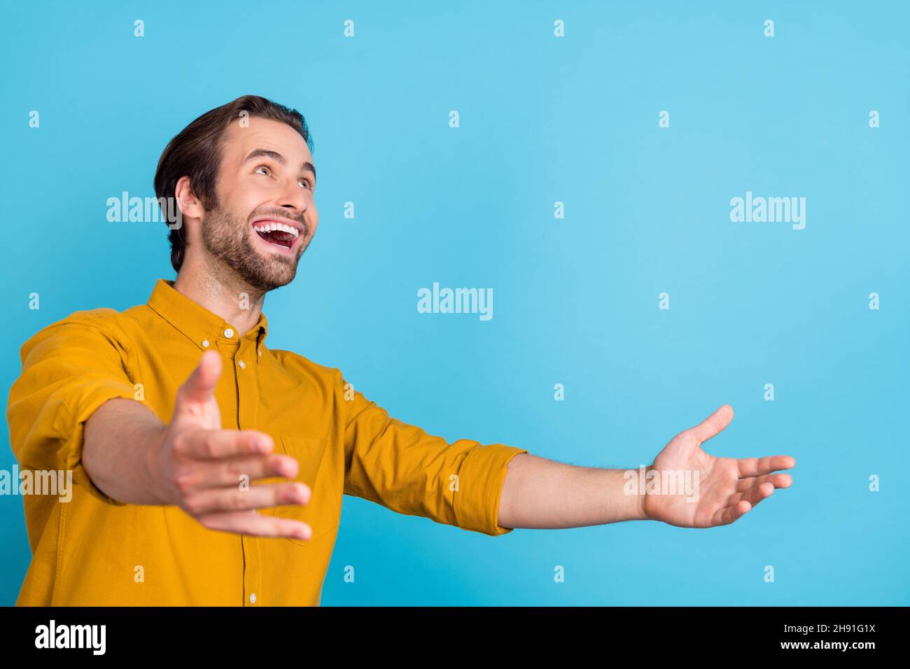 Profile photo of positive hopeful guy look empty space catch hands wear ...