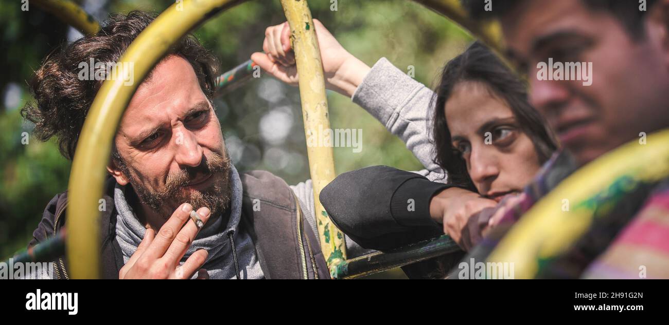 Group of young friends, female and male, smoking cannabis marijuana ...