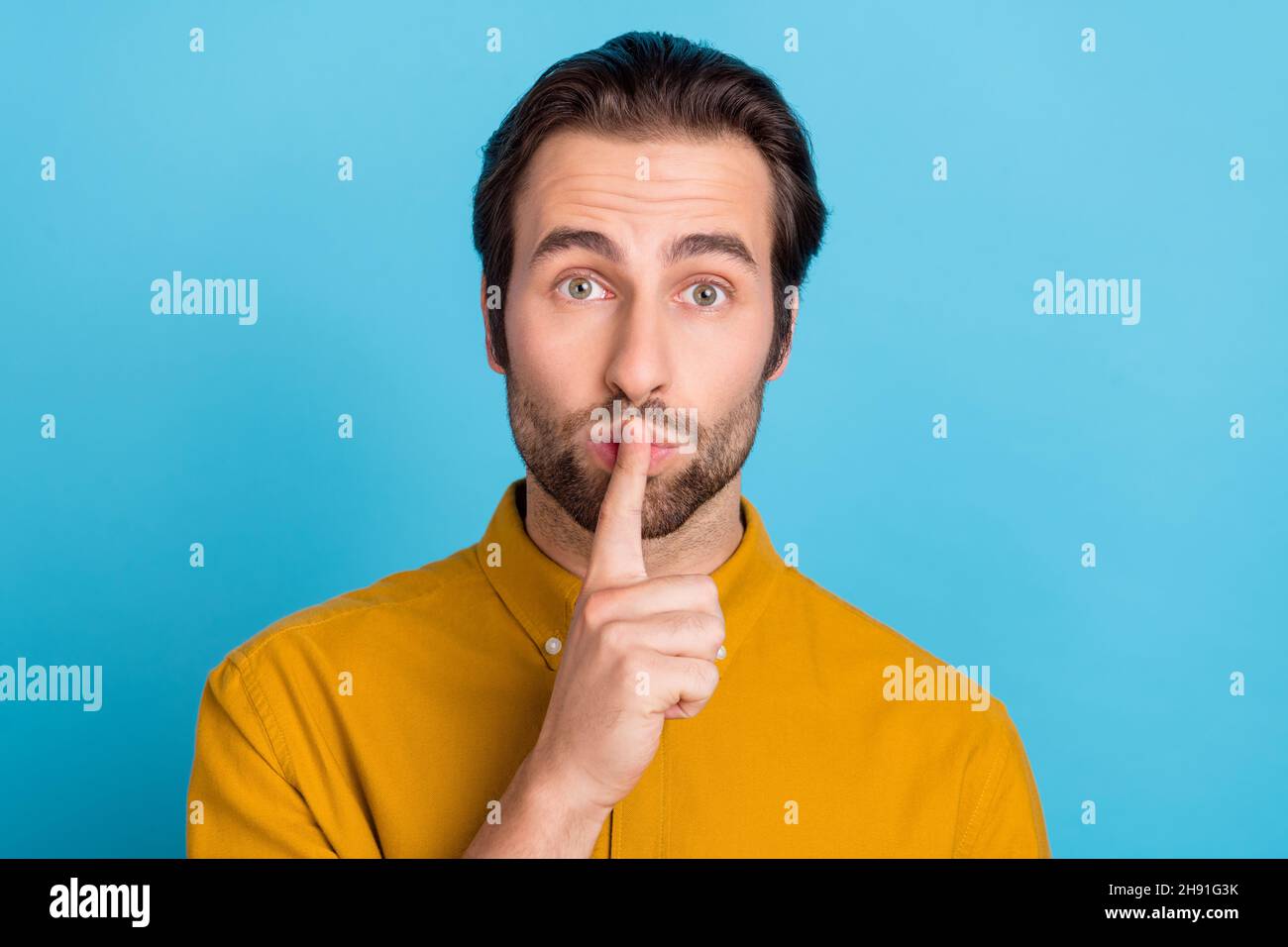 Photo of impressed millennial brunet guy finger mouth wear yellow shirt ...
