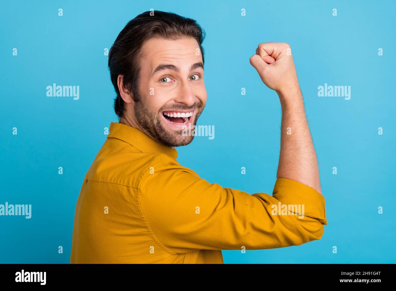 Photo of impressed millennial brunet guy yell hand fist wear yellow ...