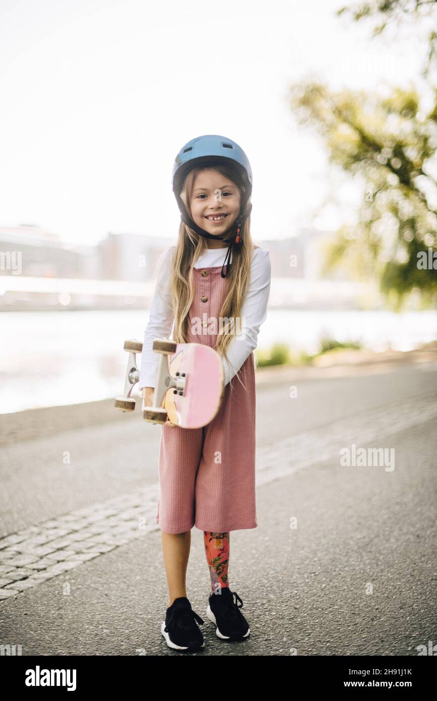 Smiling amputee girl with skateboard in park Stock Photo - Alamy