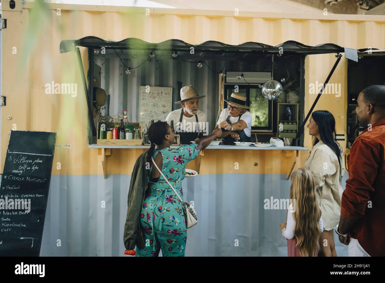 Male and female owners selling street food to customers Stock Photo - Alamy