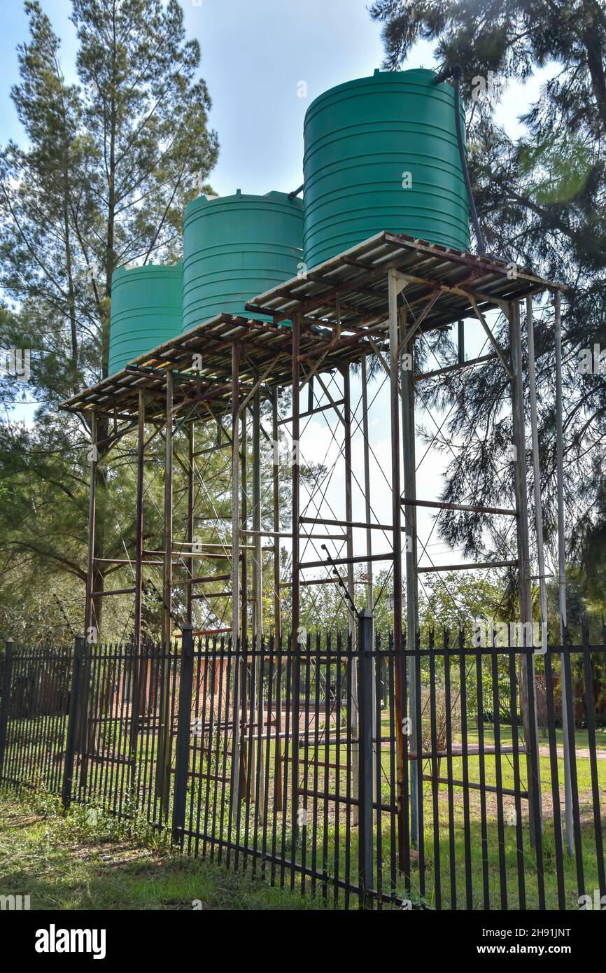 Green plastic water tanks or containers on an elevated metal structure ...