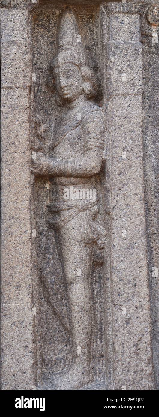 Statue of a Hindu god carved in stone. The rock is located in the ...