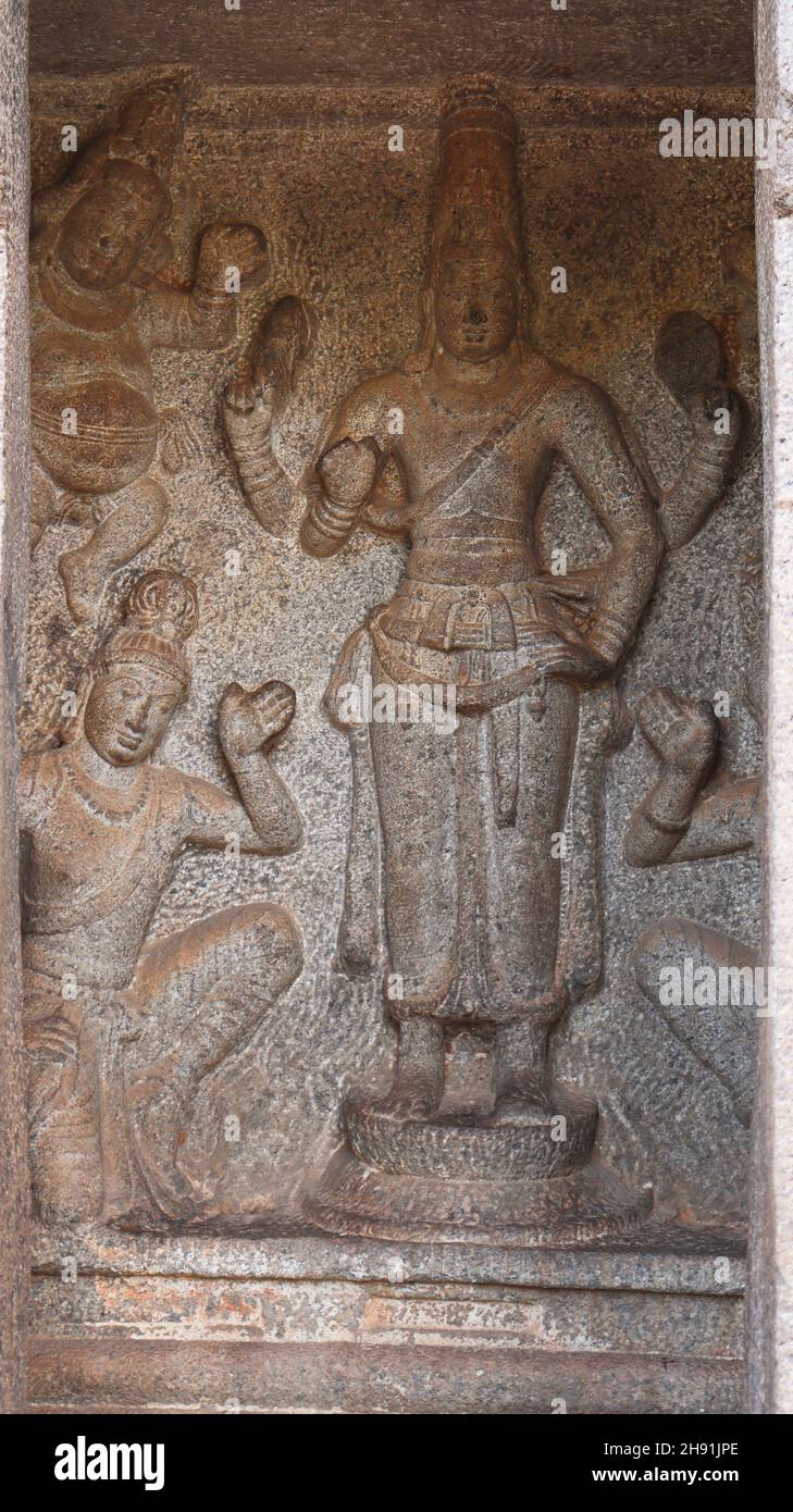 Statue of a Hindu god carved in stone. The rock is located in the ...