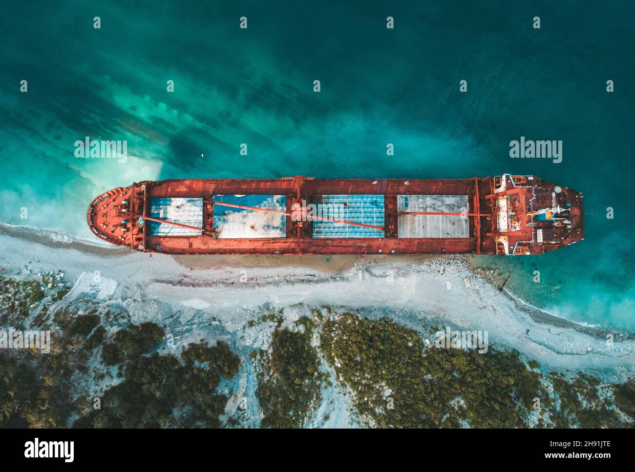 Aerial top down view of an abandoned bulk-carrier dry cargo ship washed ...