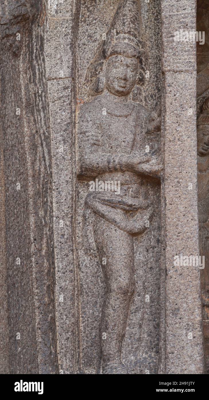 Statue of a Hindu god carved in stone. The rock is located in the ...