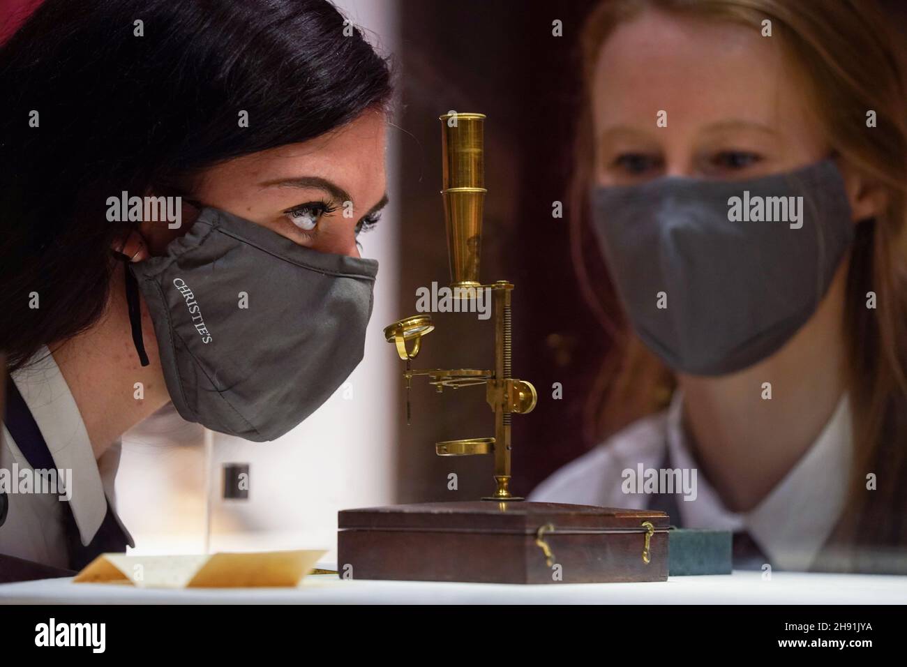 Gallery assistants look at the Charles Darwin family microscope, a ...