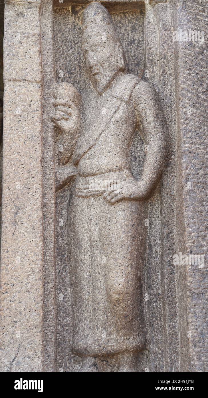 Statue of a Hindu god carved in stone. The rock is located in the ...