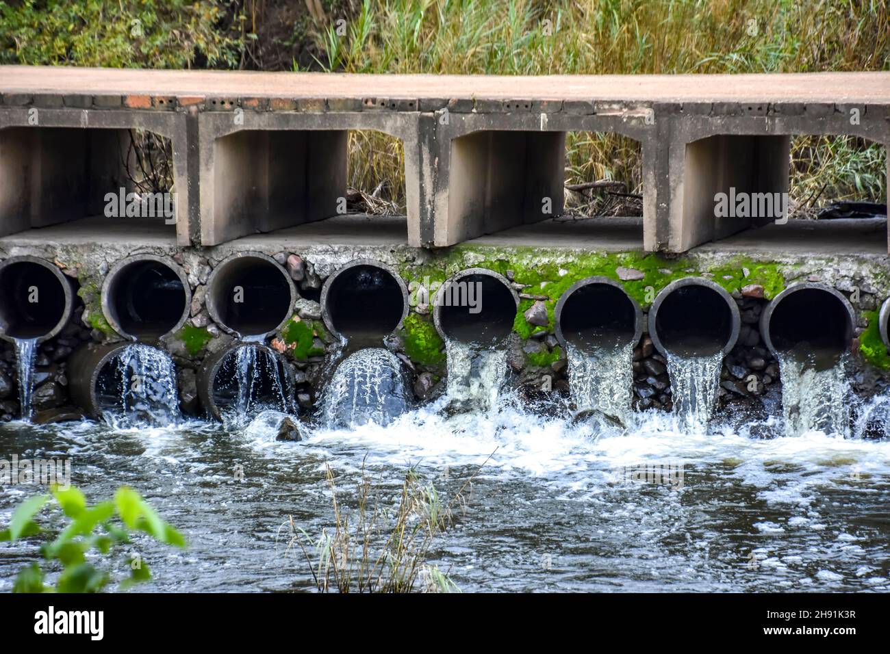 A concrete road on top of multiple sewage pipes redirecting water as a ...