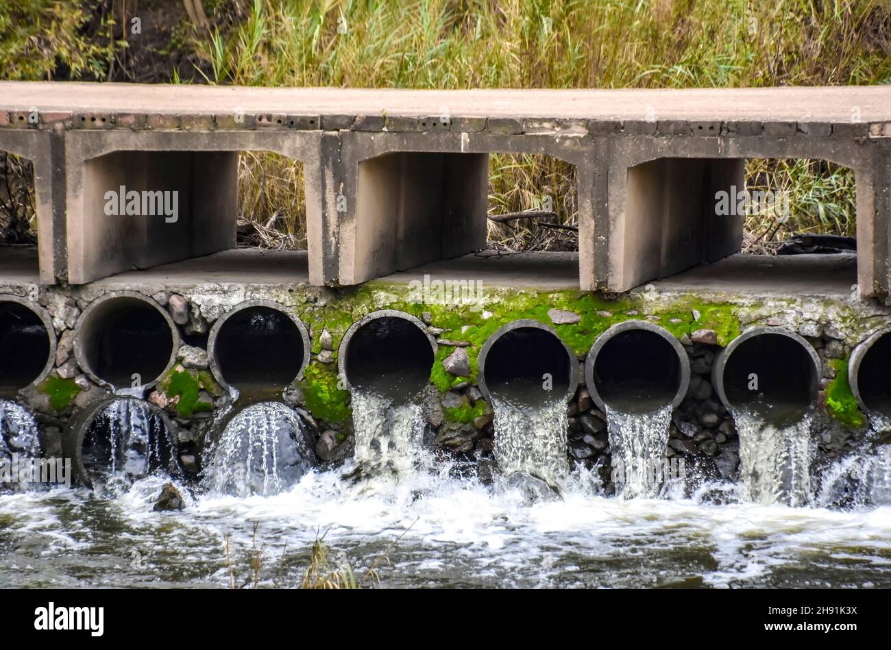 A concrete road on top of multiple sewage pipes redirecting water as a ...