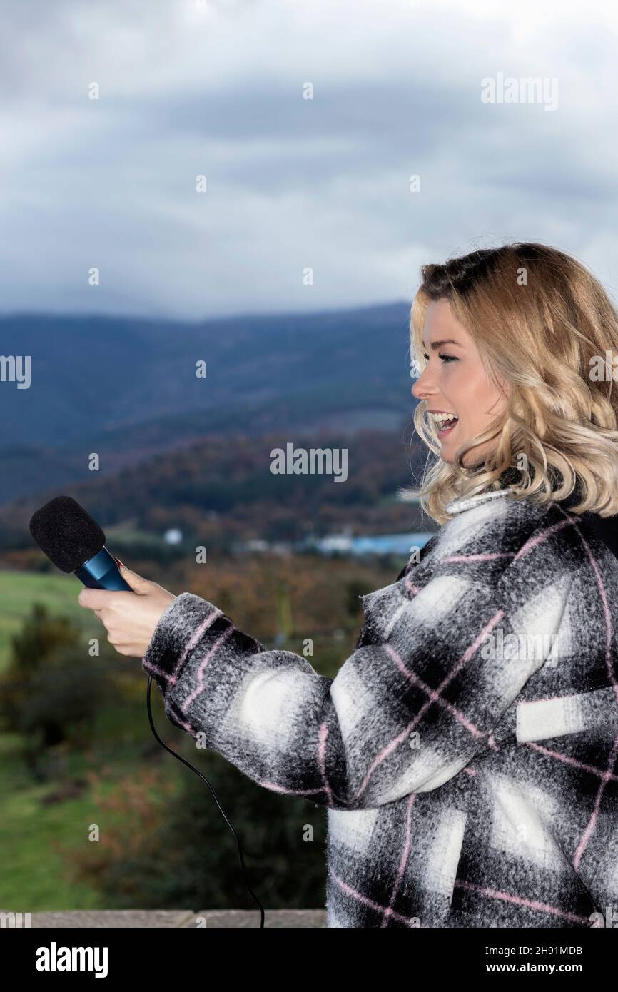 blonde journalist doing an outdoor interview Stock Photo - Alamy