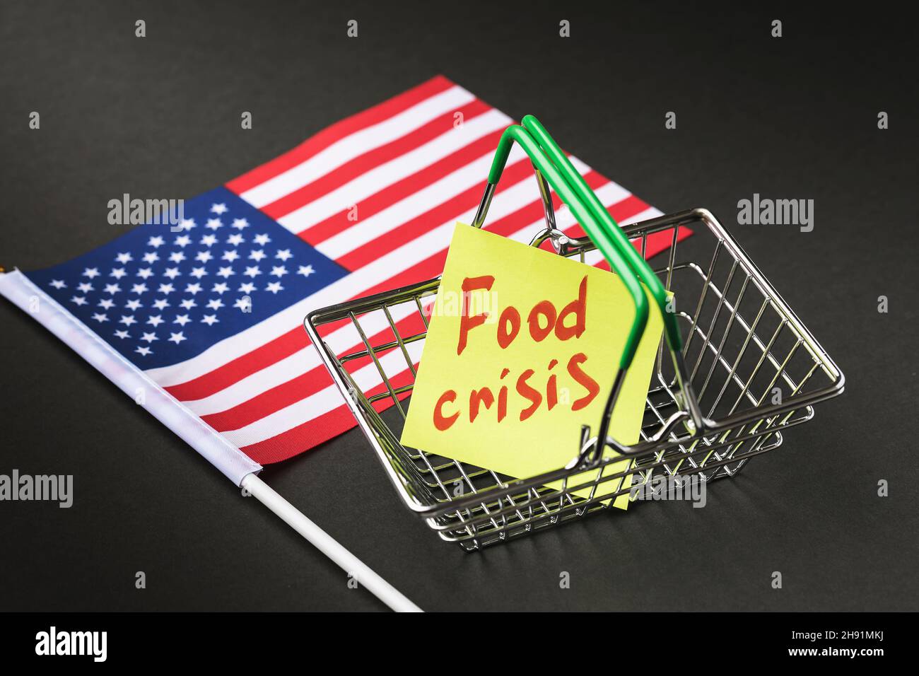 American flag and note with text in empty food basket on dark ...