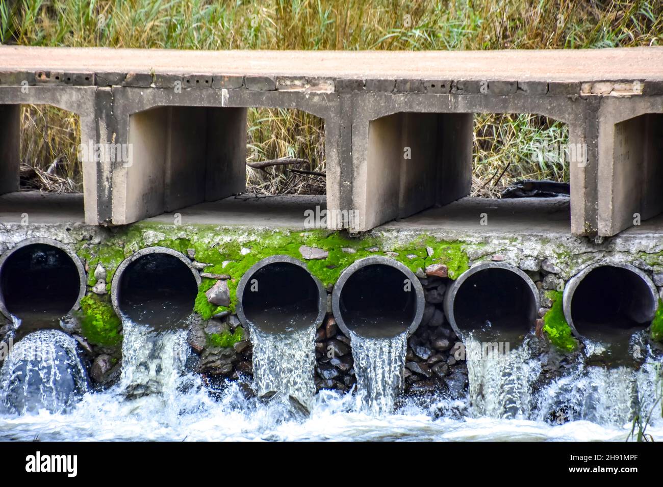 A concrete road on top of multiple sewage pipes redirecting water as a ...