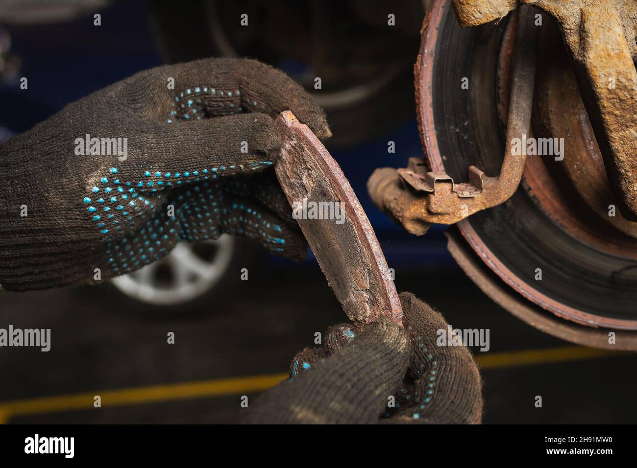 An auto mechanic shows the degree of wear of a car brake pad, close-up ...