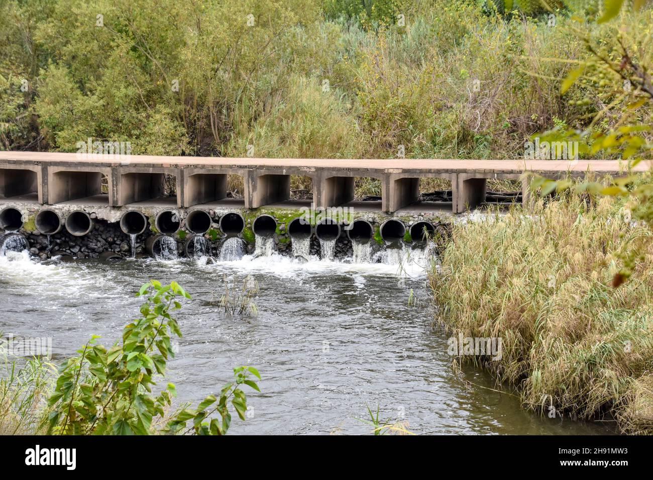 A concrete road on top of multiple sewage pipes redirecting water as a ...