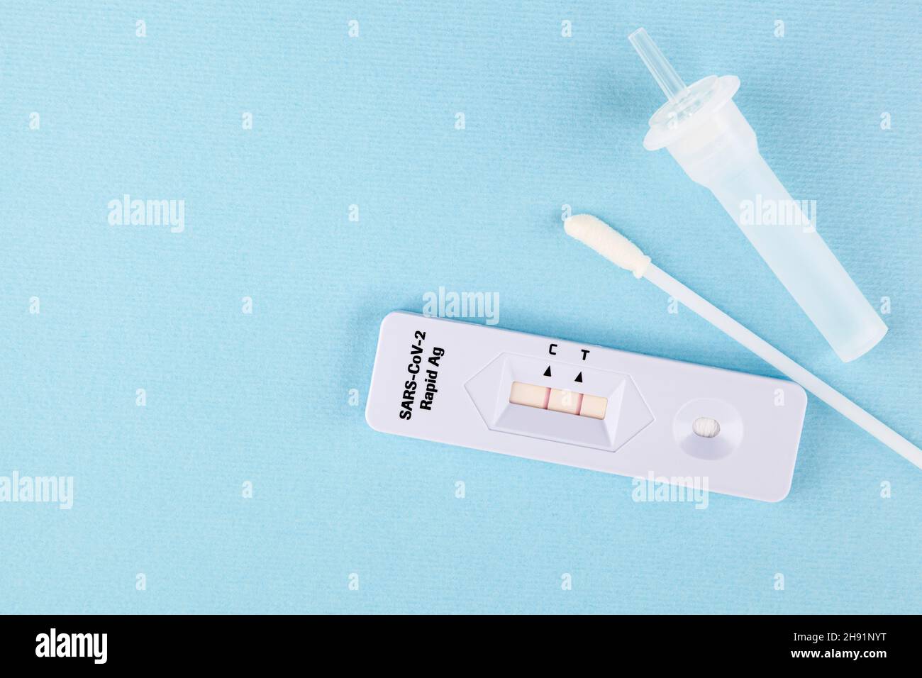 Positive result in rapid Ag Covid test on blue background. Copy space ...