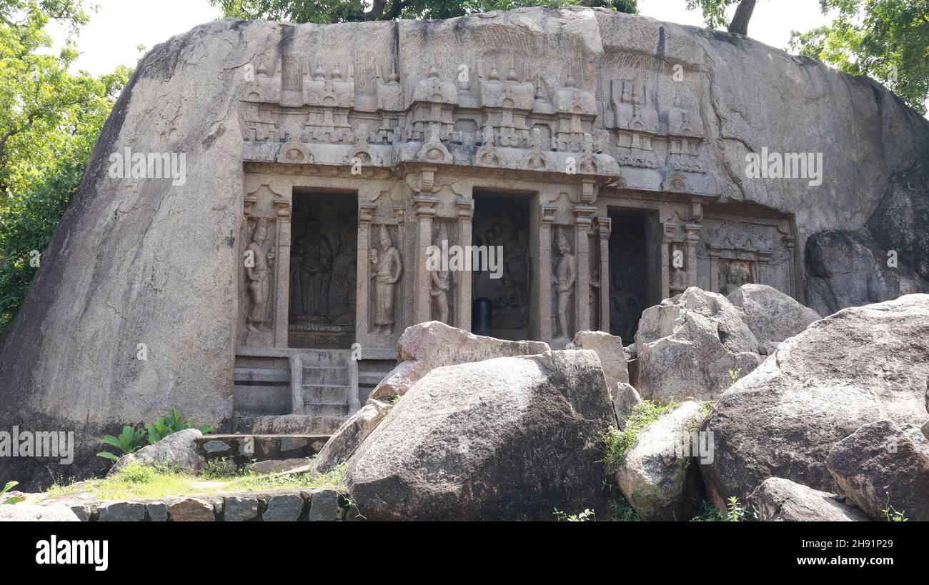 The cave temple is carved in stone and has sculptures and statues ...