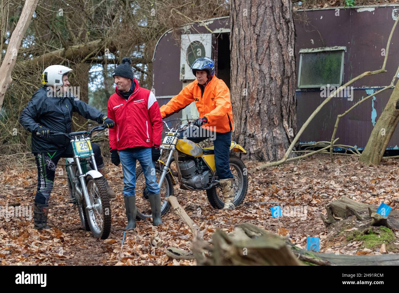 Two competitors and a spectator chat at a Suffolk motorcycle trial ...