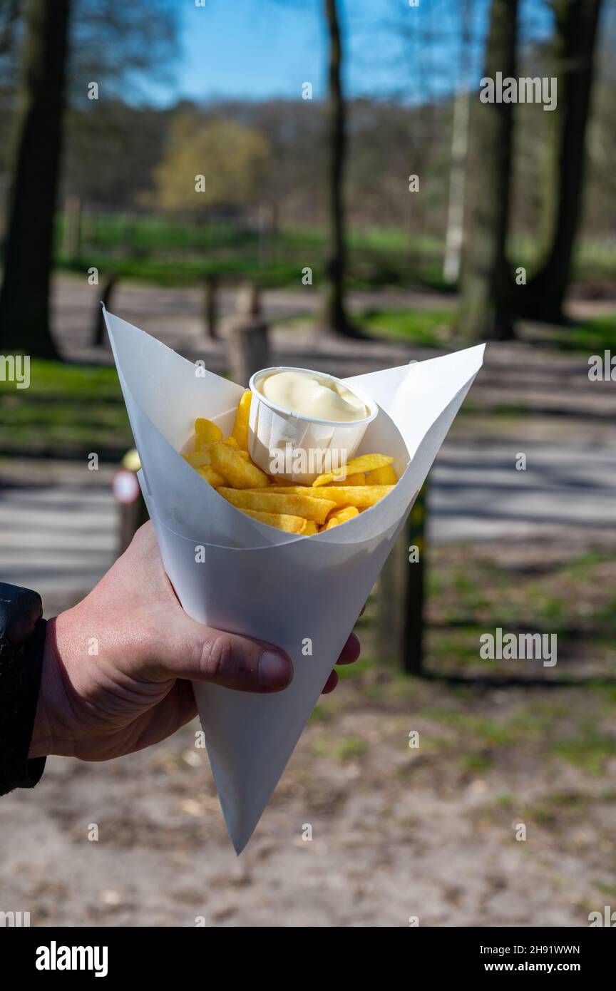 Eating of street or take away food fresh baked french fried potatoes ...