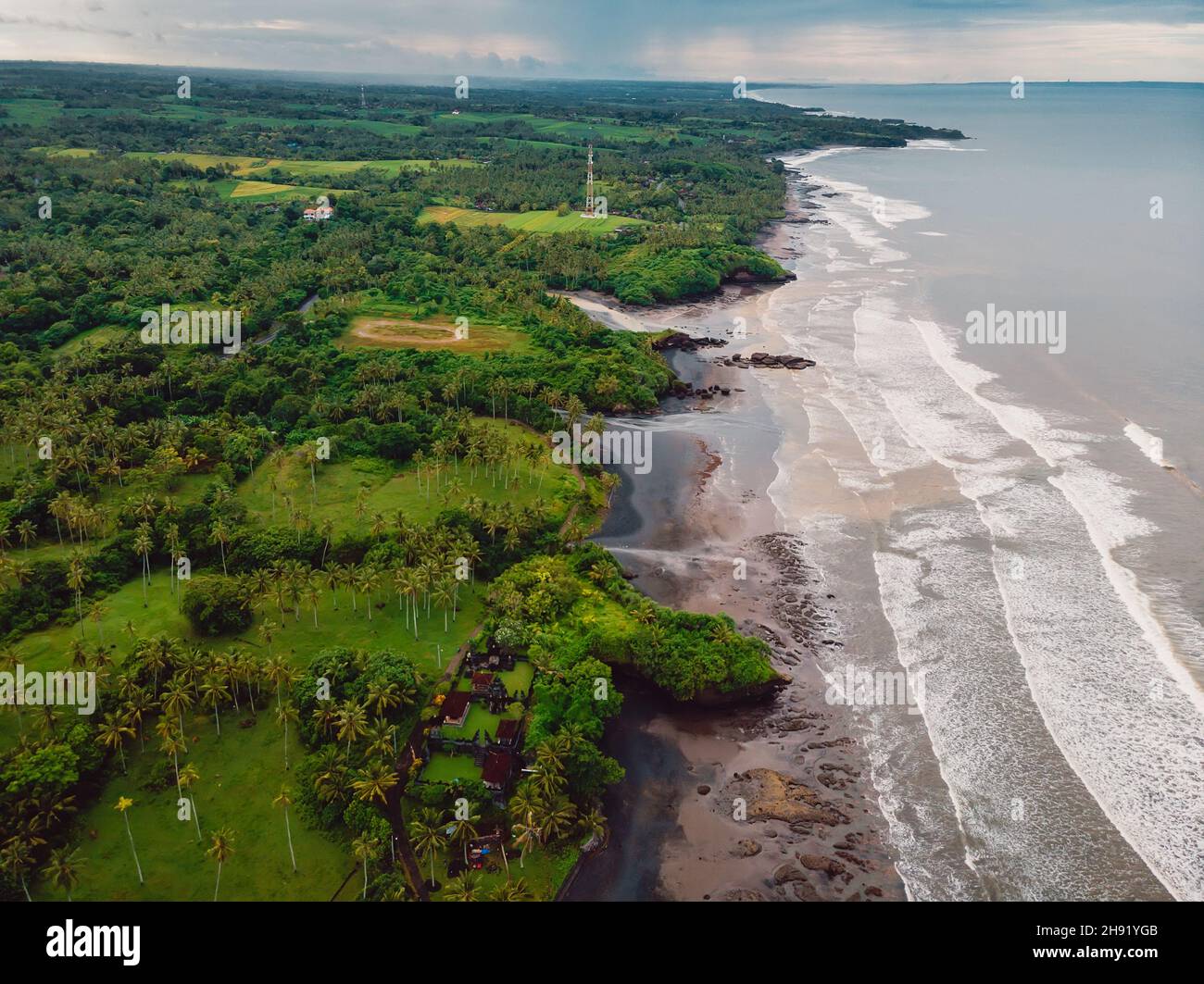 Aerial view of black sand beach with ocean and waves in Balian, Bali ...