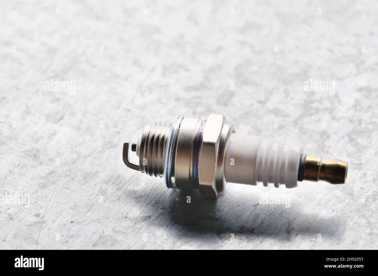 New spark plug for internal combustion engine on metal background ...