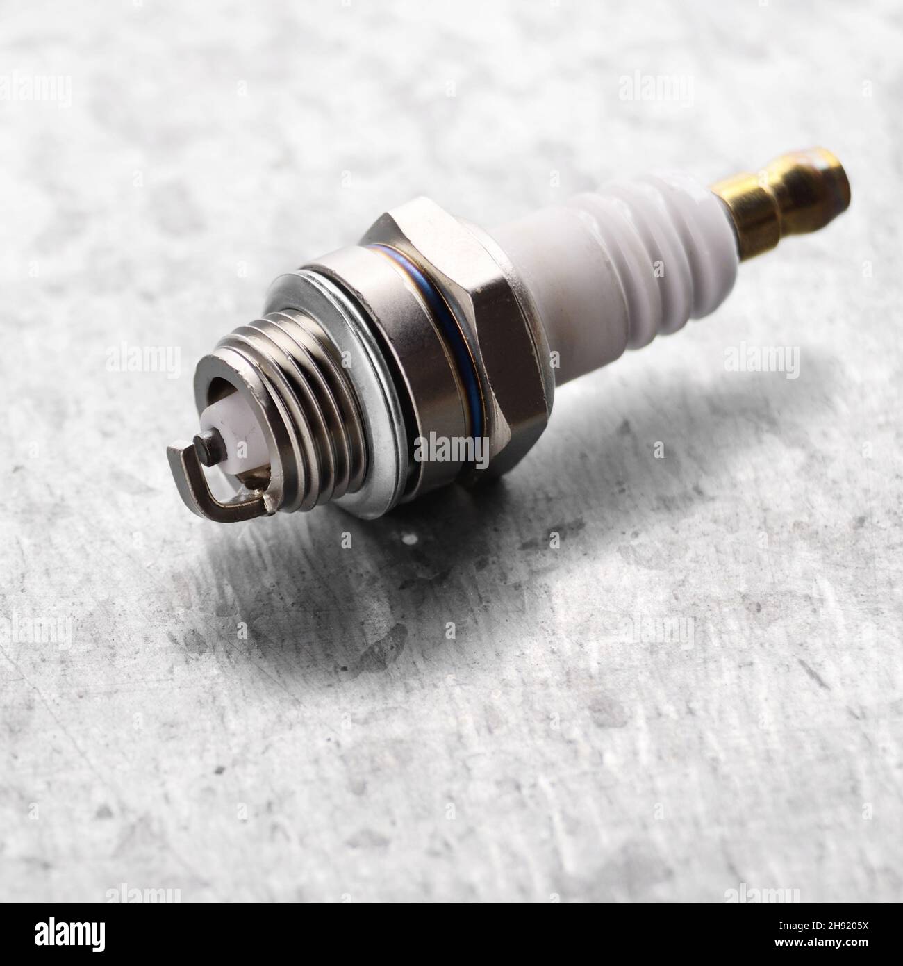 New spark plug for internal combustion engine on metal background ...