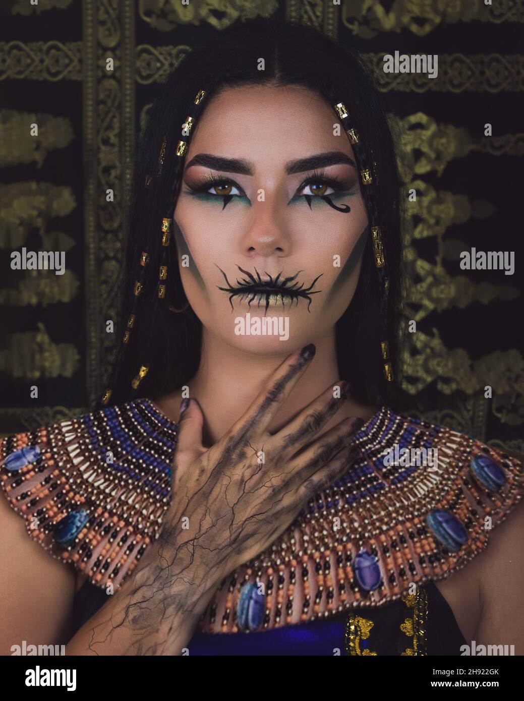 Woman wearing mayan outfit with colored face with black lips standing ...