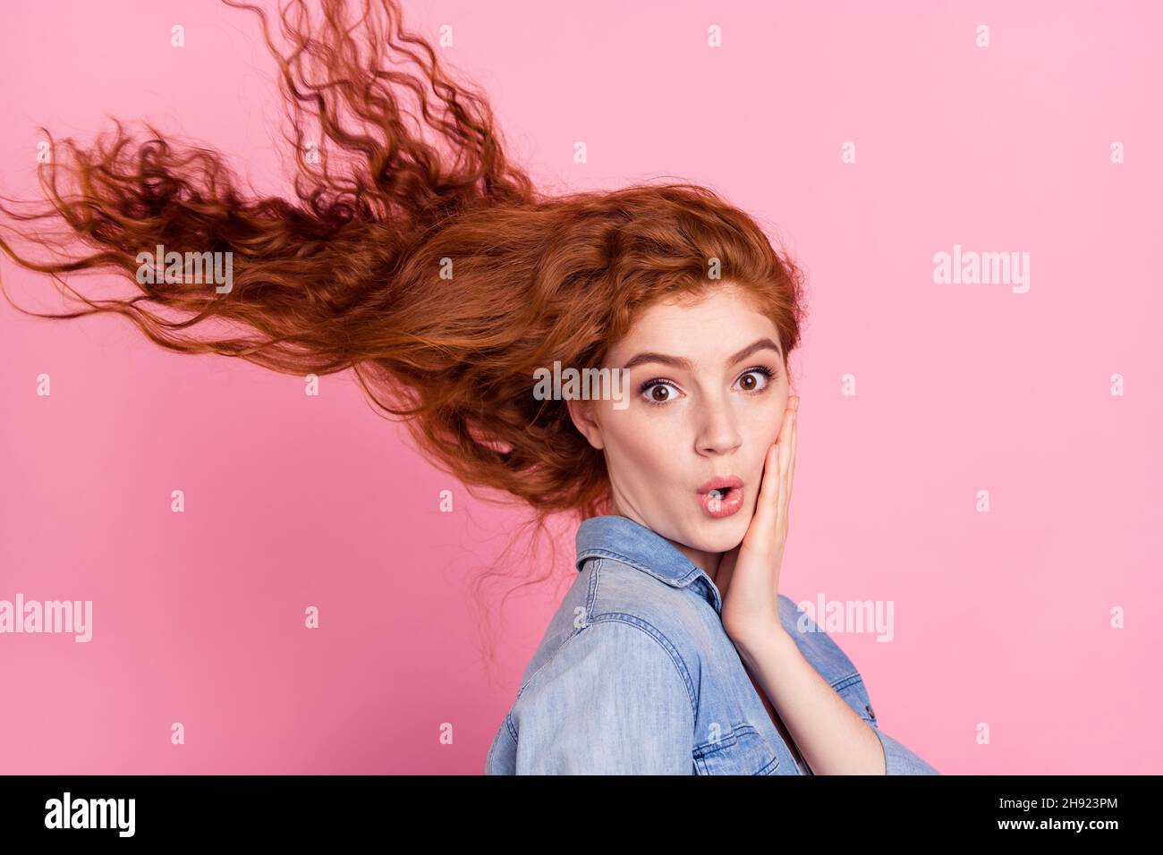 Photo of impressed funny young woman wear denim shirt arm cheek wind ...