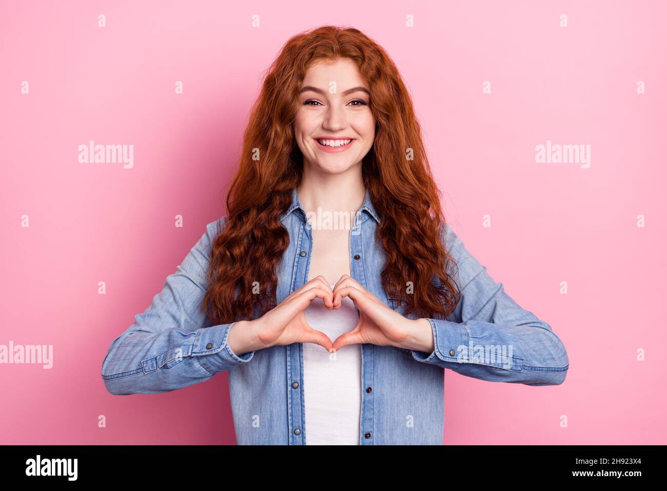 Photo of young attractive girl showing fingers heart symbol love romantic date concept isolated ...