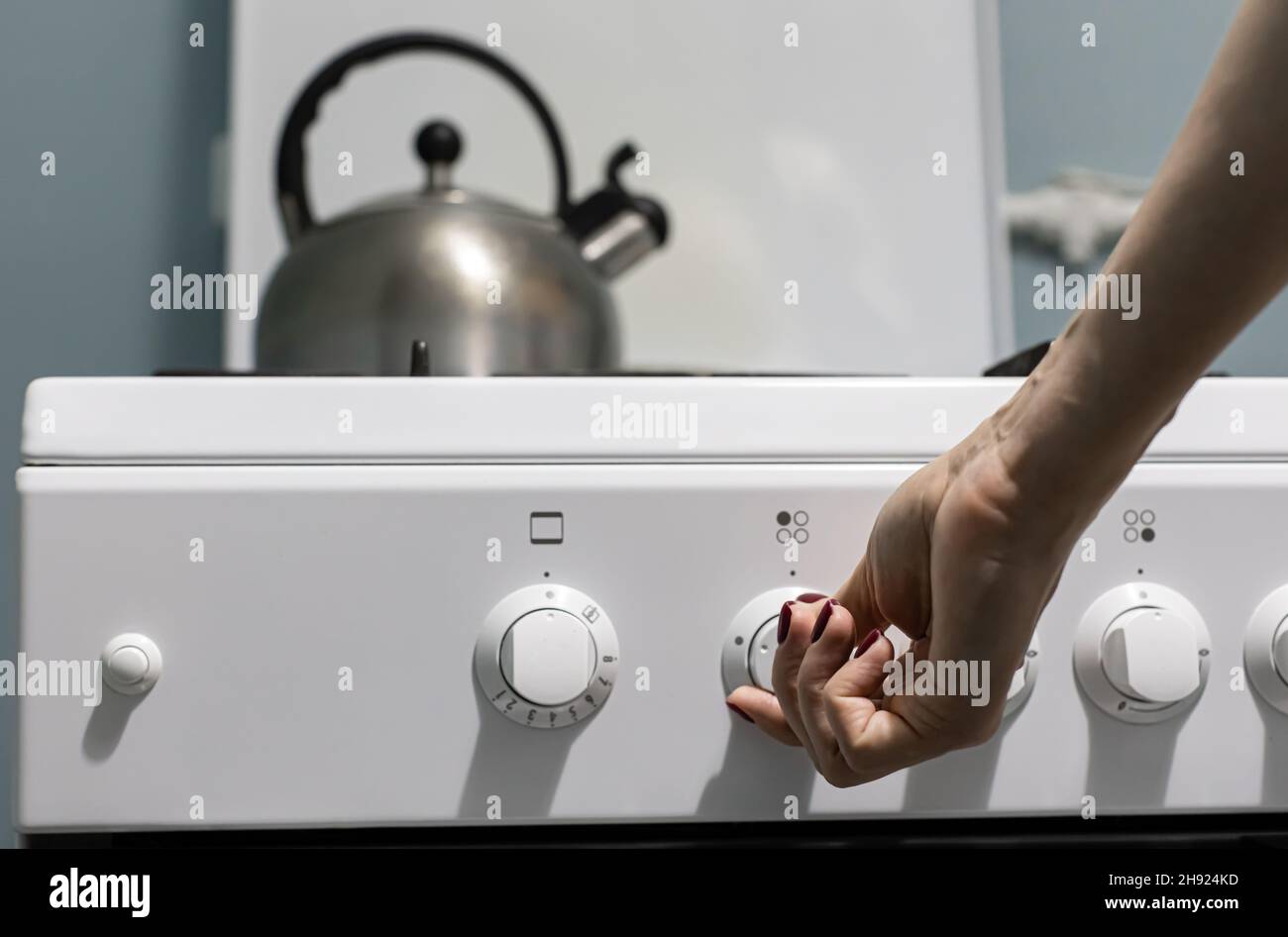 a person adds gas on the stove where the kettle is. High quality photo ...
