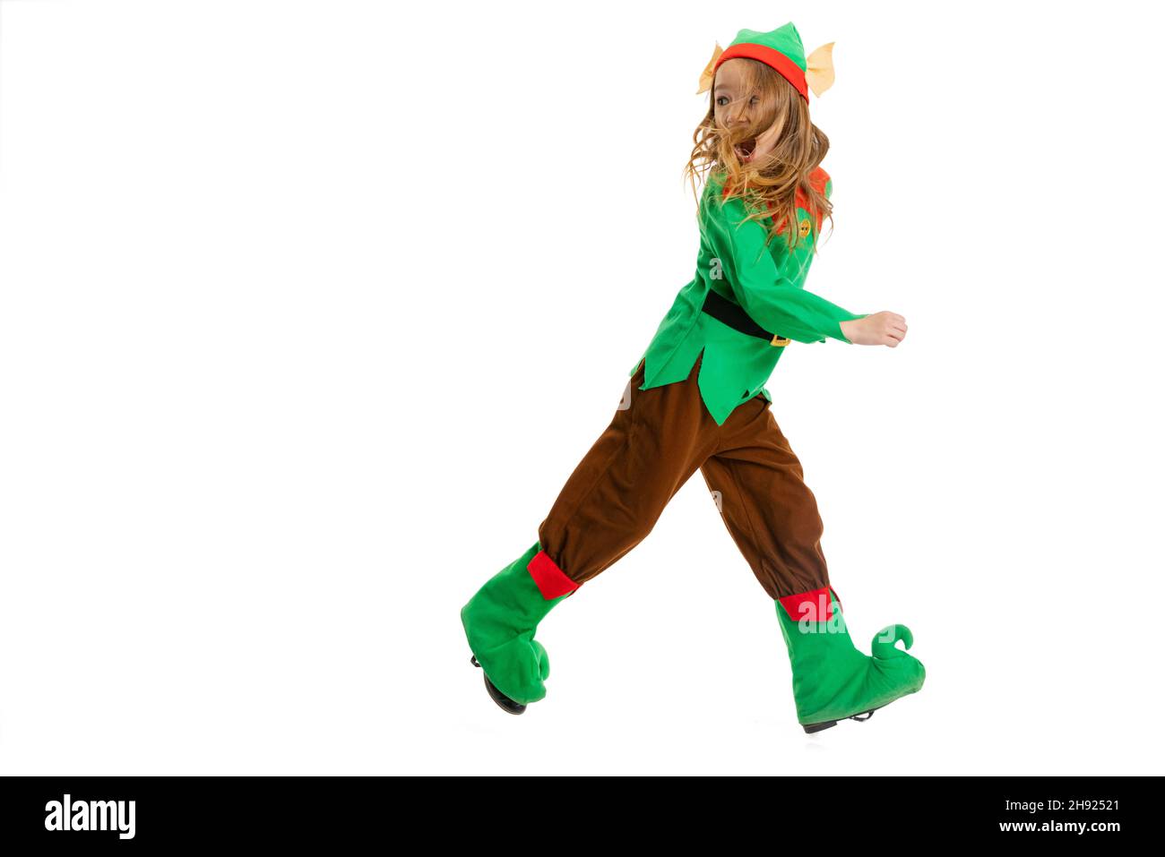 Happy smiling little girl dressed like funny gnome or elf running ...