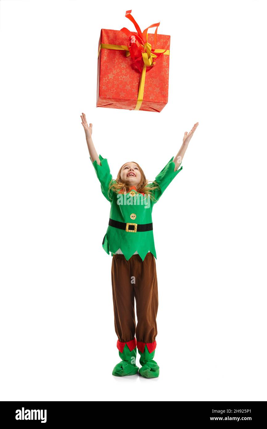 Close-up of happy little girl dressed like funny gnome or elf tossing ...