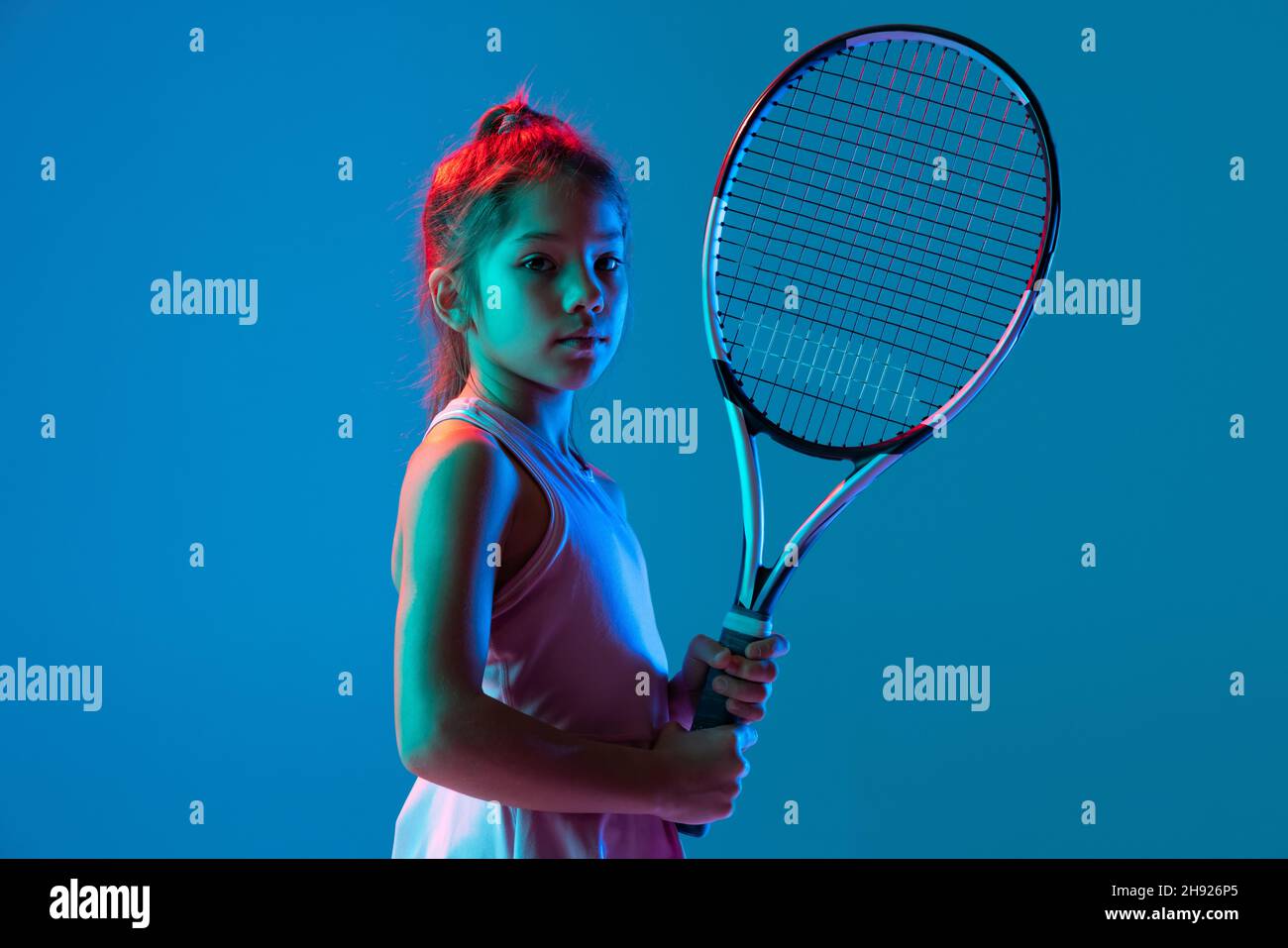 Half-length portrait of little girl, beginner tennis player posing with ... Half-length portrait of little girl, beginner tennis player posing with ...
