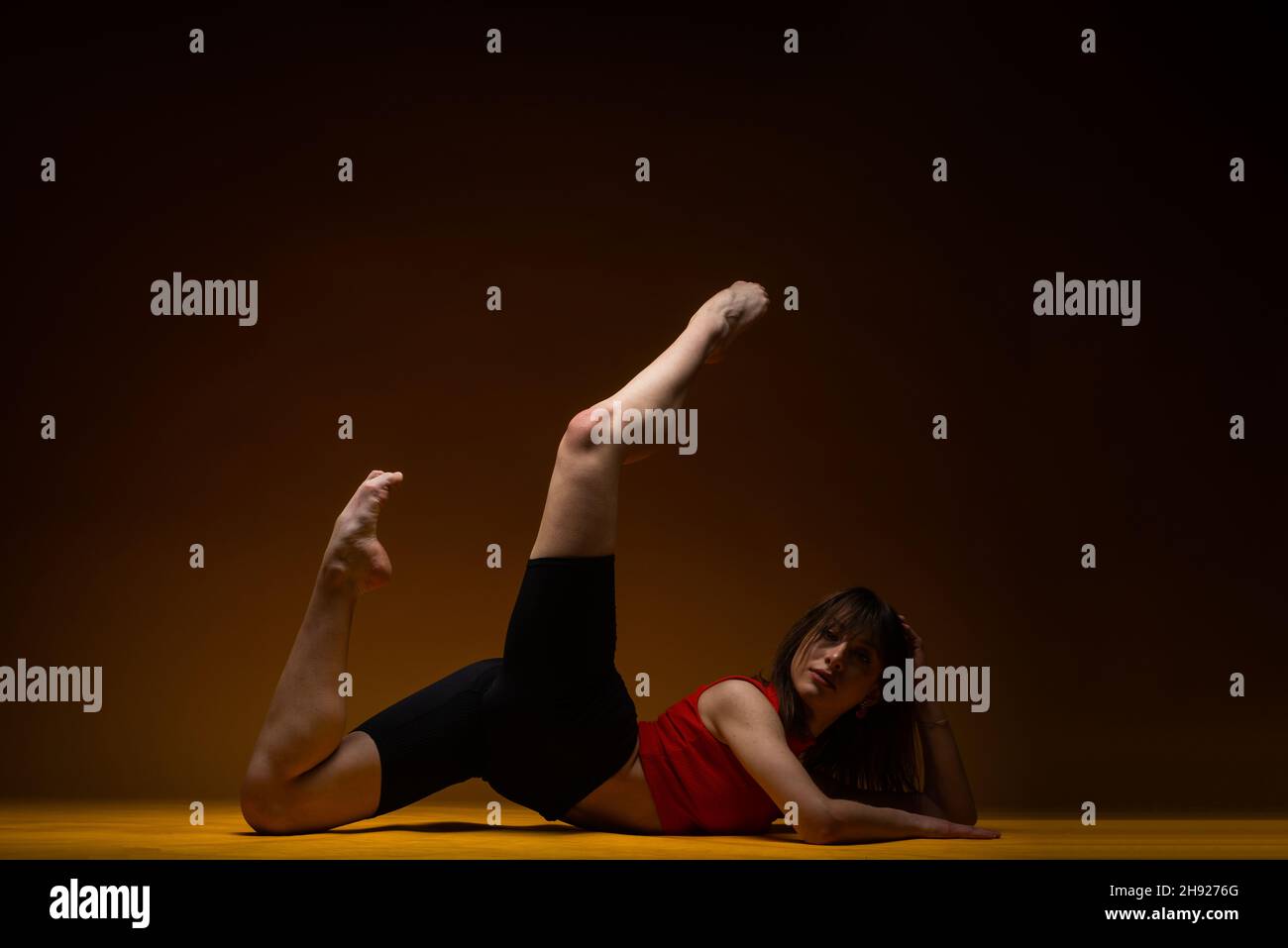Ballerina girl is doing a perfect laying ballet pose with her legs up ...