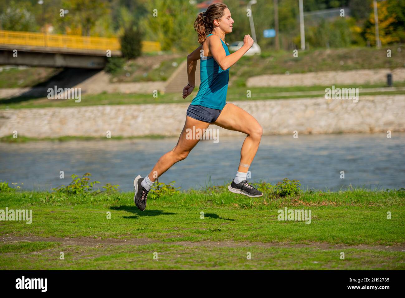 Attractive and beautiful fit girl is making a big steps while running ...