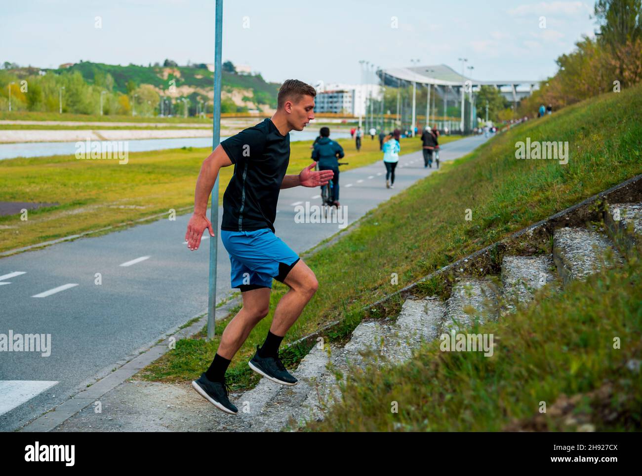 American muscular man in jogger shorts running upwards with efforts on ...