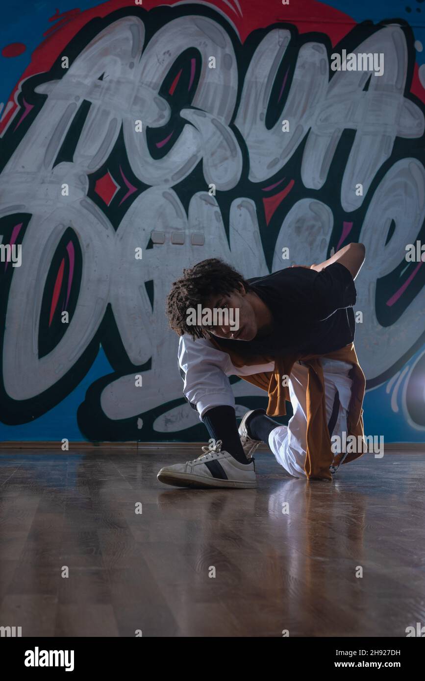 African American hip hop dancer (breakdancer) performing over graffiti ...