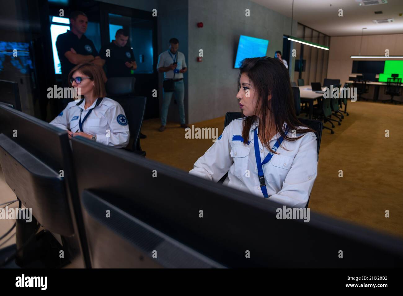 Female security guards working on computers while sitting in the main ...